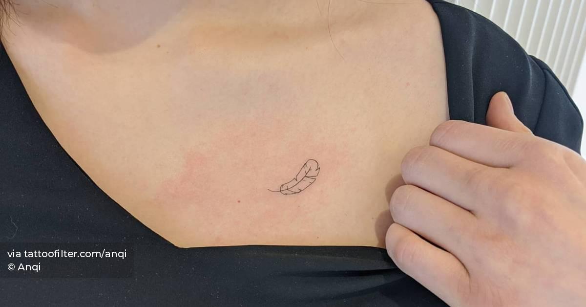 Fine line feather tattoo located on the chest.