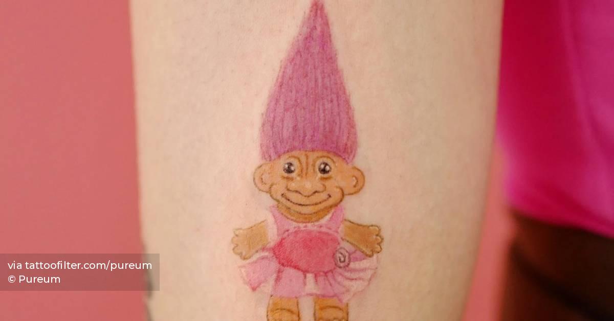 Troll doll tattooed on the inner forearm.