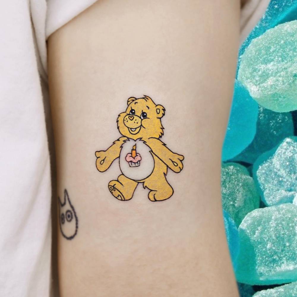 Cartoon Style Care Bear Tattoo Located On The Bicep 