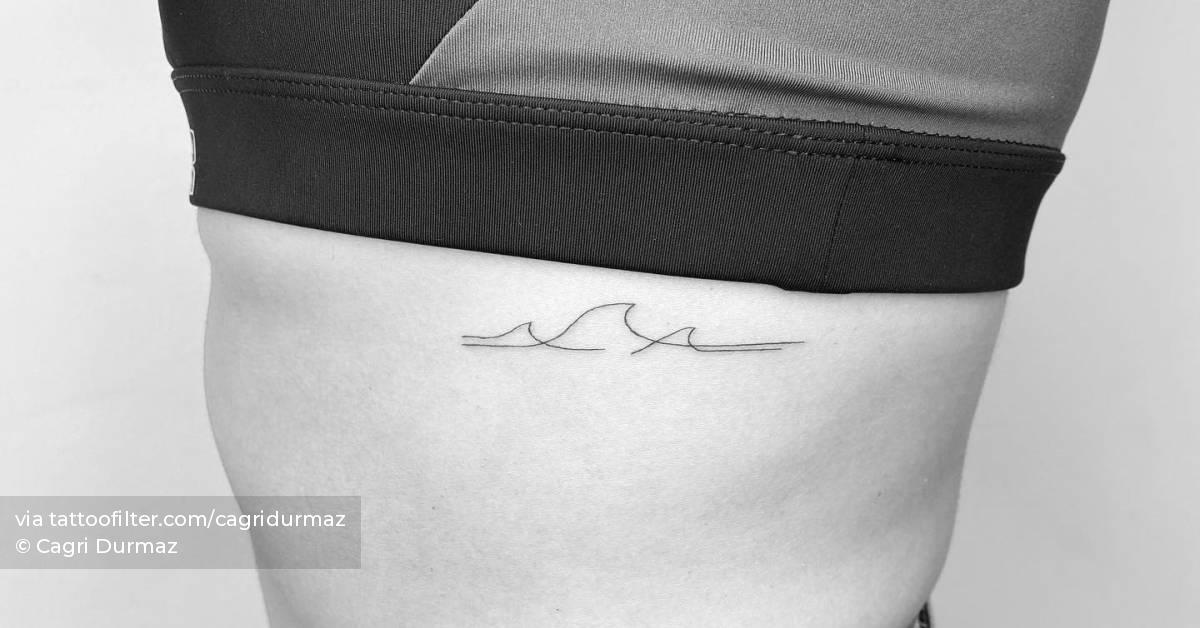 Minimalistic style waves tattooed on the rib.
