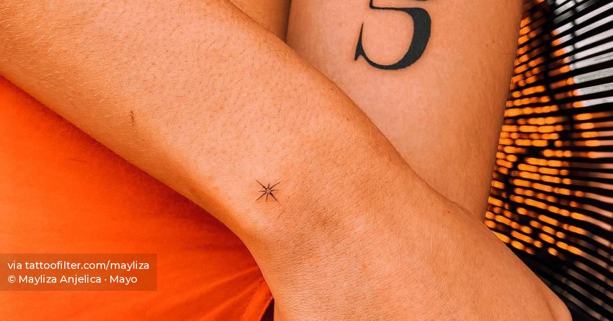 Number "5" tattoo located on the inner forearm.