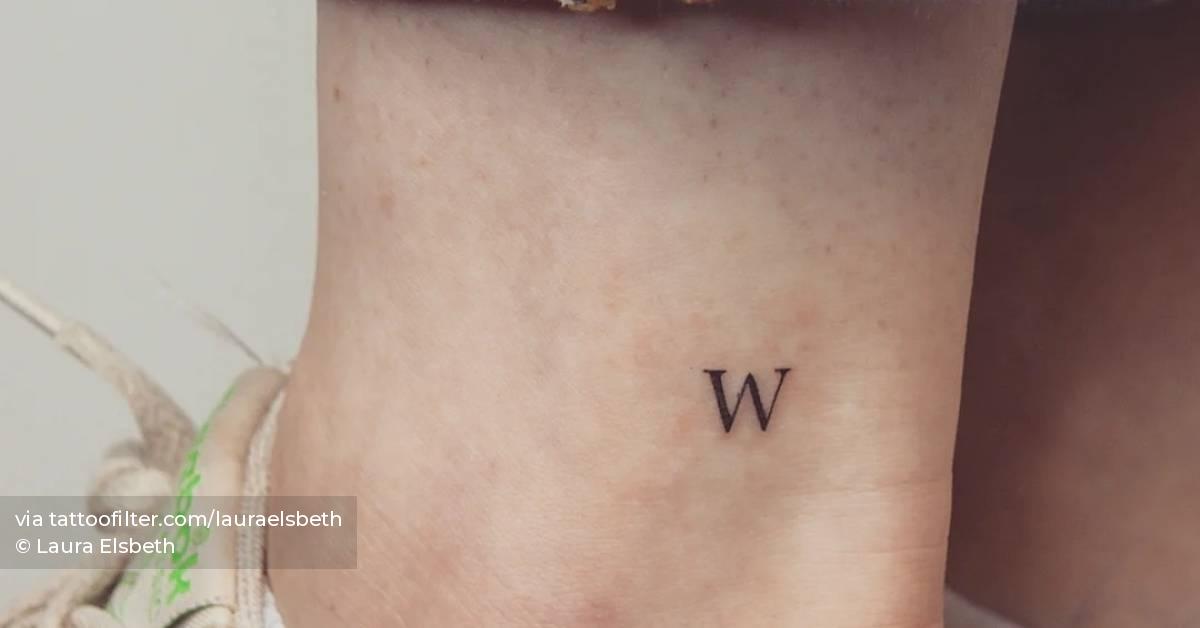 Tiny letter "W" tattoo located on the ankle.
