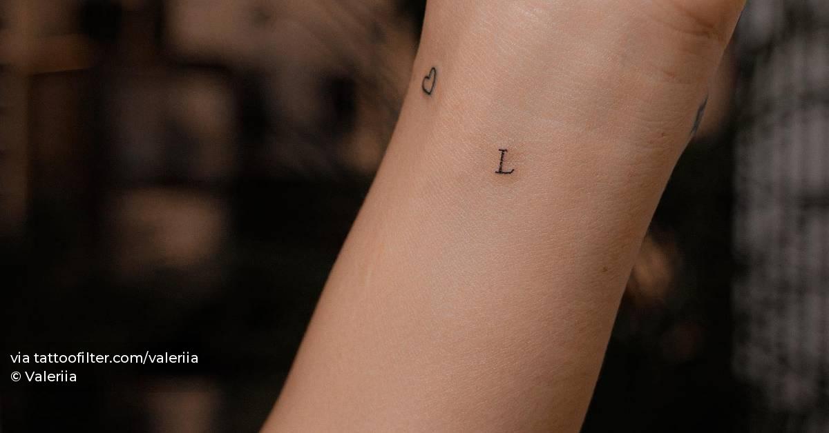Minimalistic letter "L" tattoo placed on the wrist.