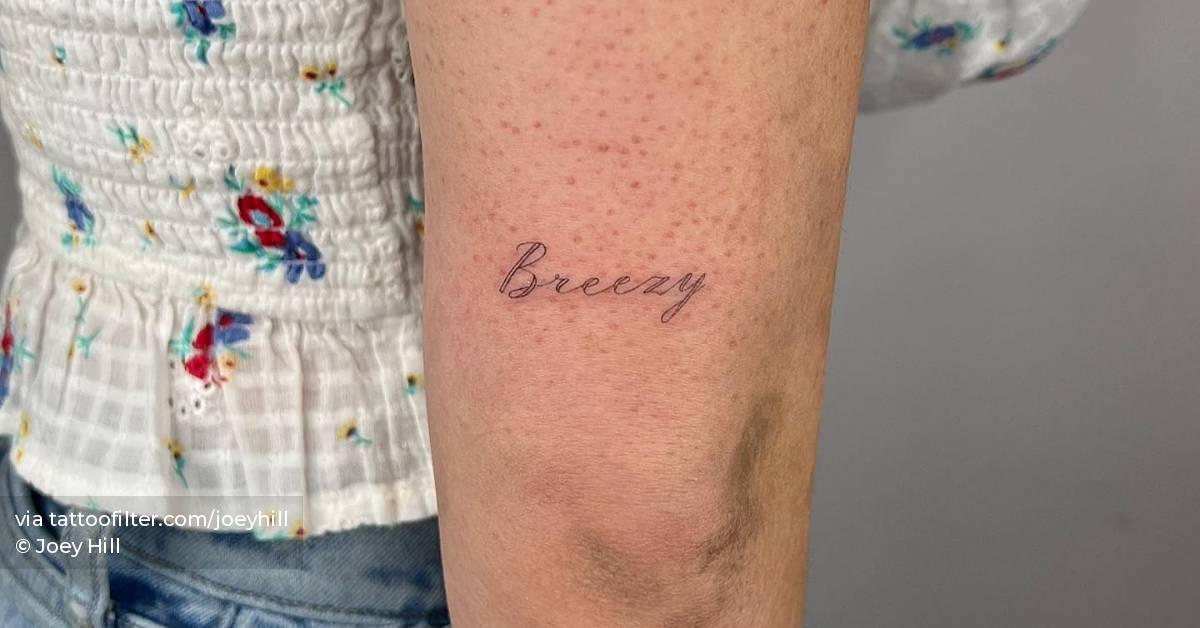 Word "breezy" tattooed on the tricep.