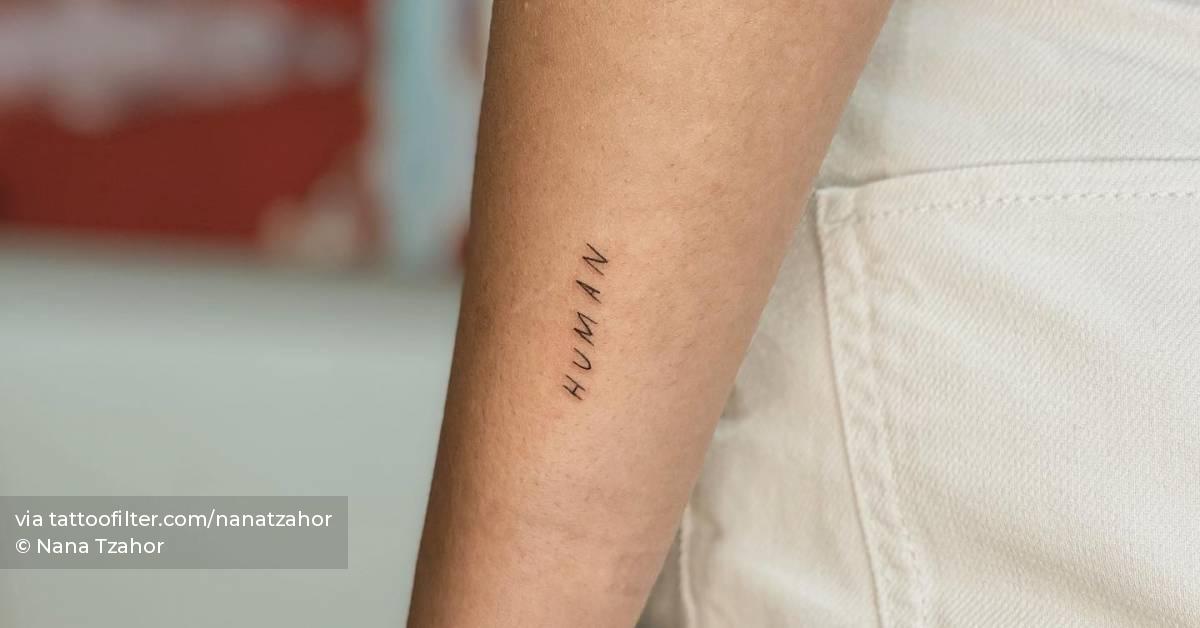 Tattoo of the word "human" handwritten on the forearm.