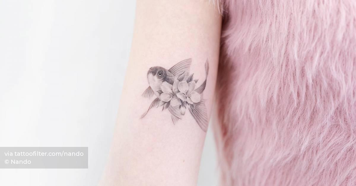 Single needle floral fish tattooed on the tricep.