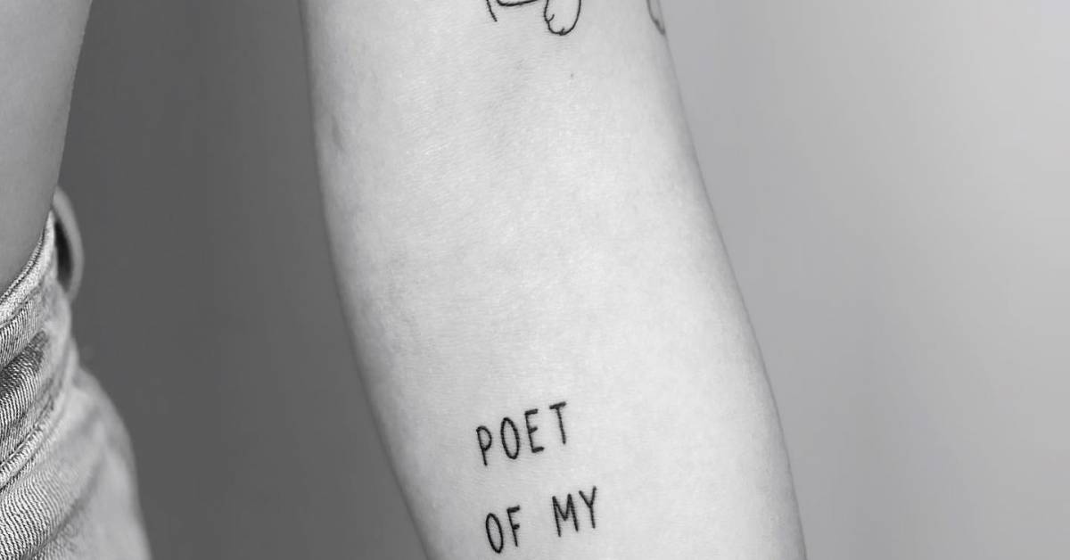 "Poet of my heart" lettering tattoo located on the