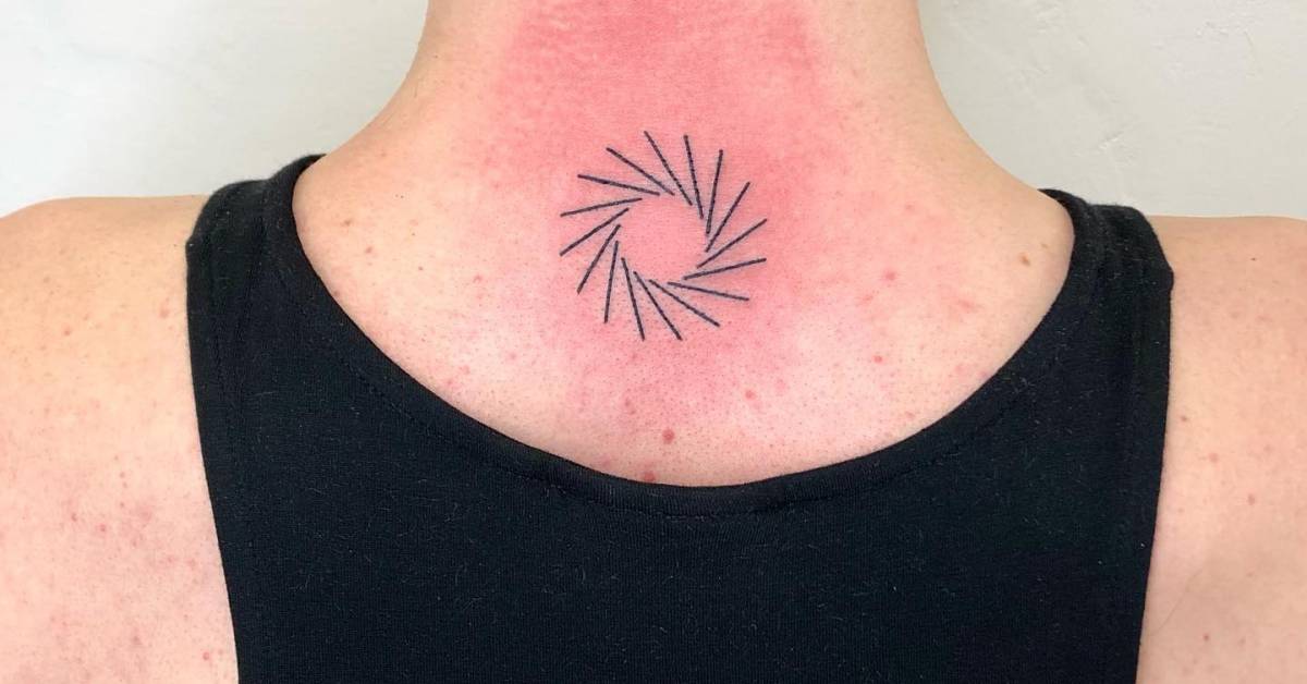 Line art sun tattoo done on the upper back.
