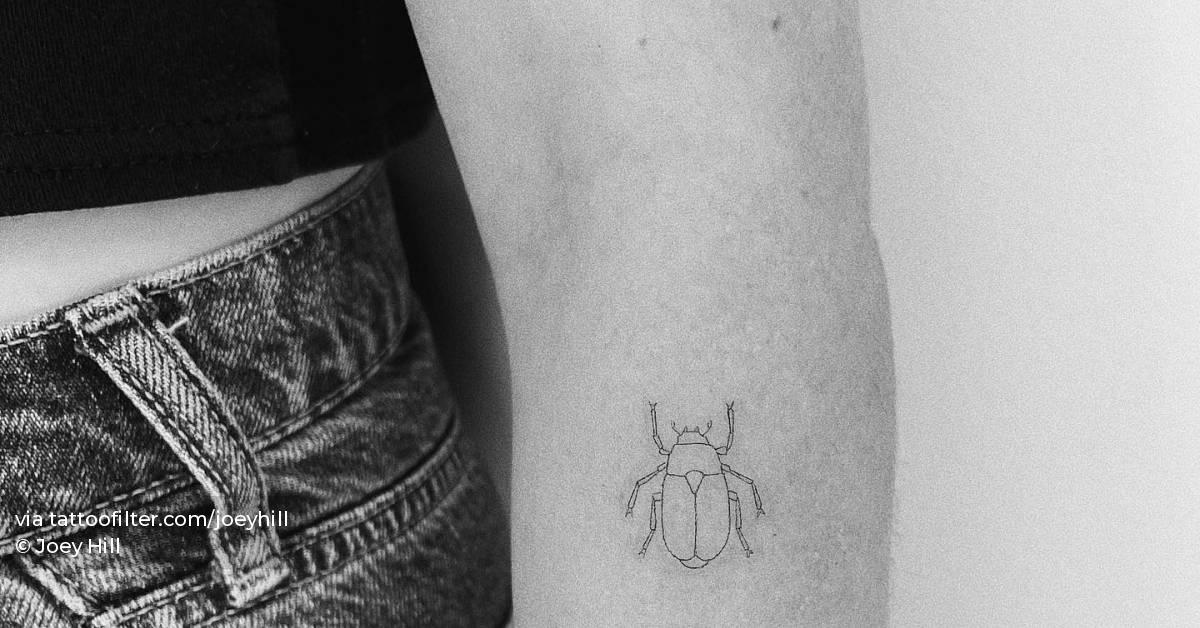 Fine line beetle tattoo located on the forearm.