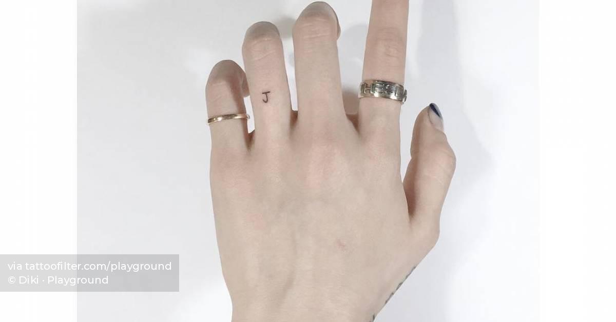 Tattoo of a minimalistic letter "J" located on the