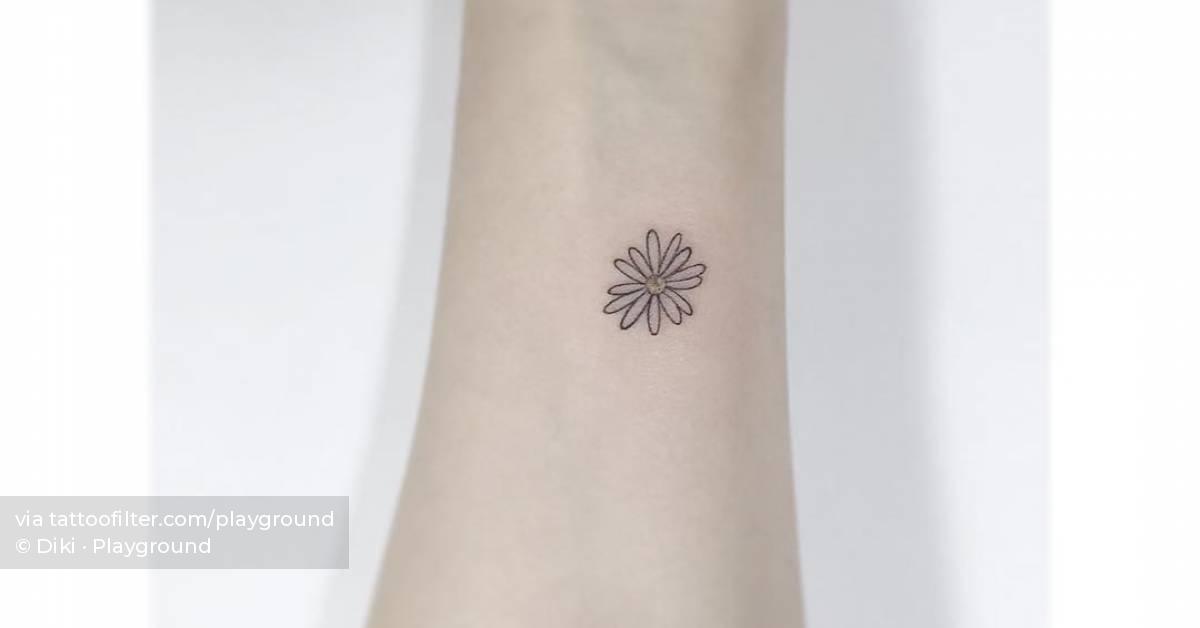 Fine line daisy flower tattoo done on the wrist.