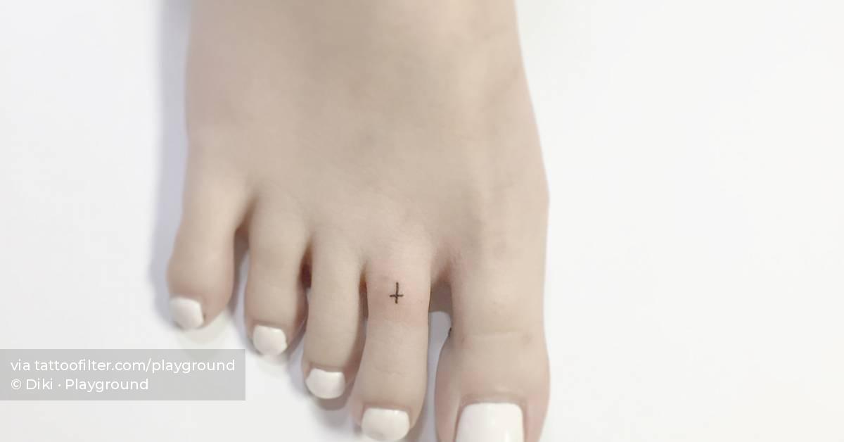 Micro tattoo of a cross done on the toe.