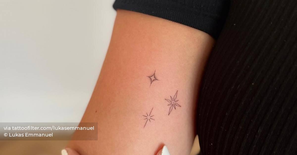 Fine line stars tattooed on the inner arm.