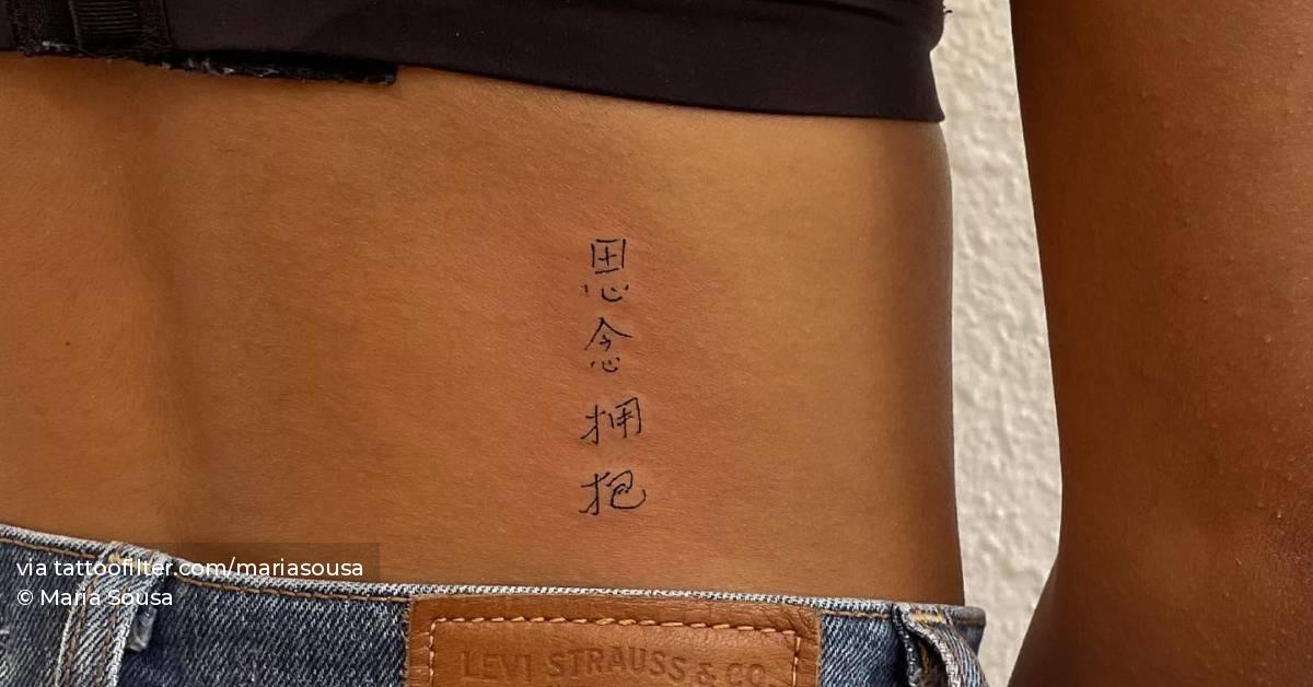 Chinese characters tattoo located on the lower back.