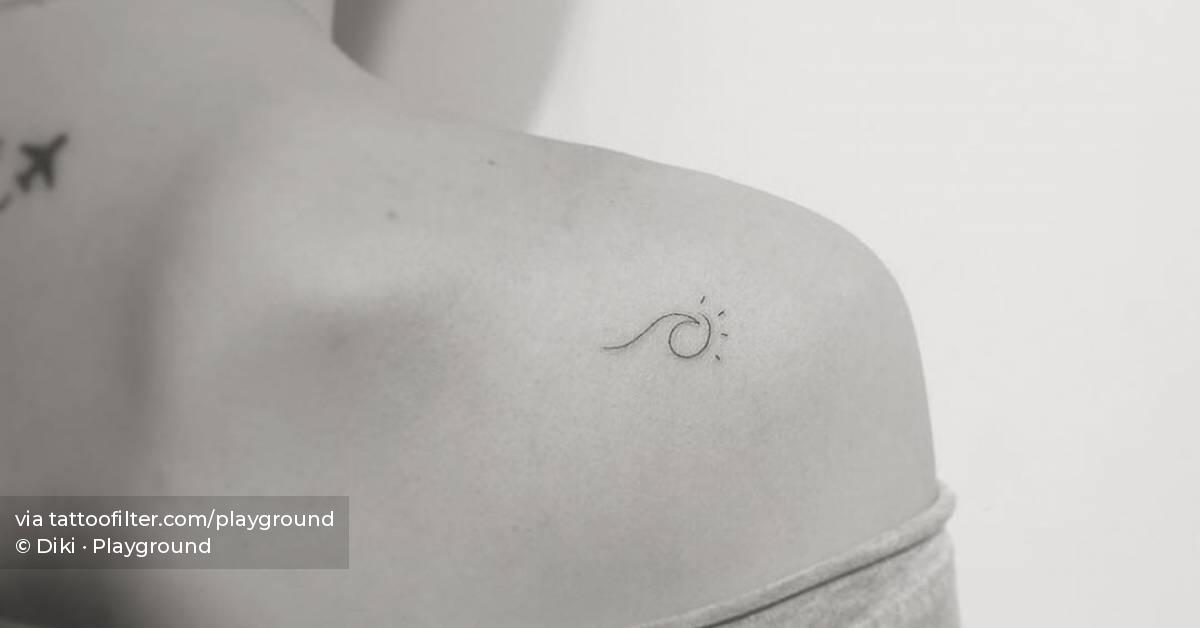 Sun and wave tattoo located on the shoulder blade.