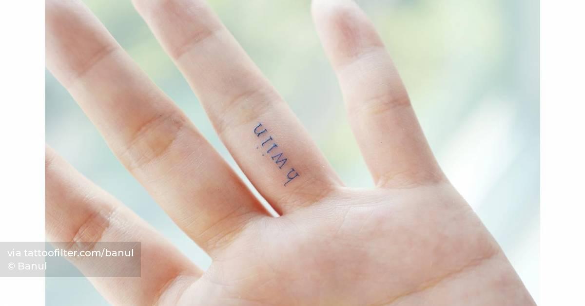 Lettering tattoo in blue ink done on the finger.