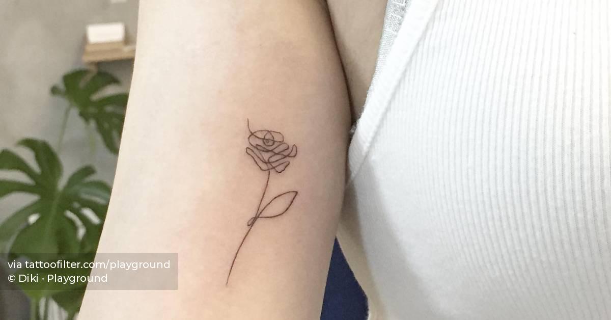 One line rose tattooed on the inner arm.