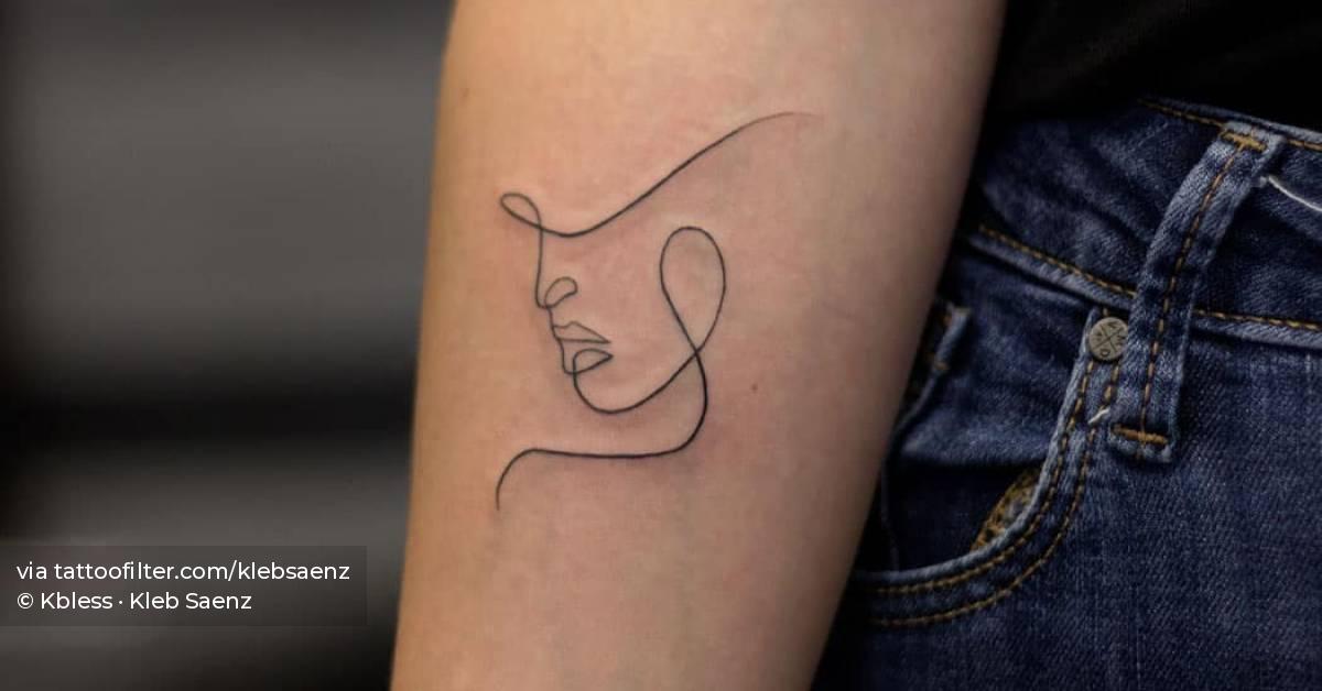 One line face tattooed on the inner forearm.