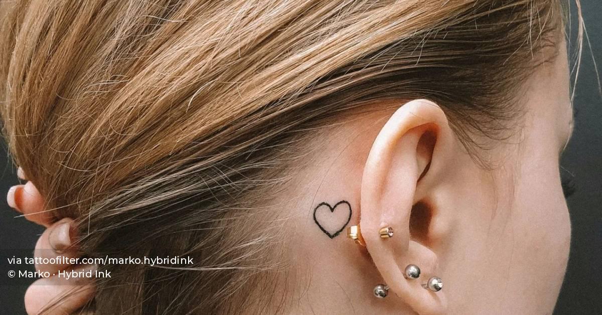 Minimalistic style heart tattooed behind the ear.