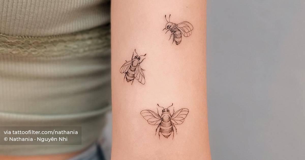 Fine line bees tattooed on the bicep.