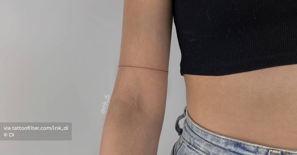 Fine line bracelete tattooed on the upper arm,