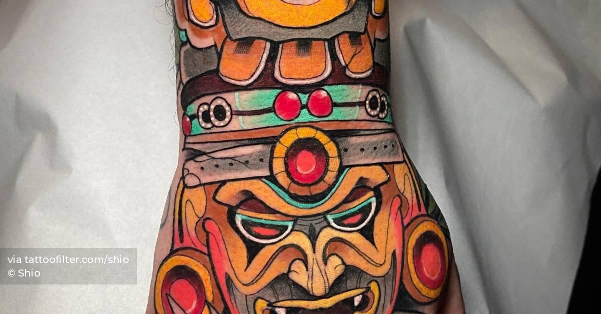Ancient mask tattoo done on the hand, neotraditional