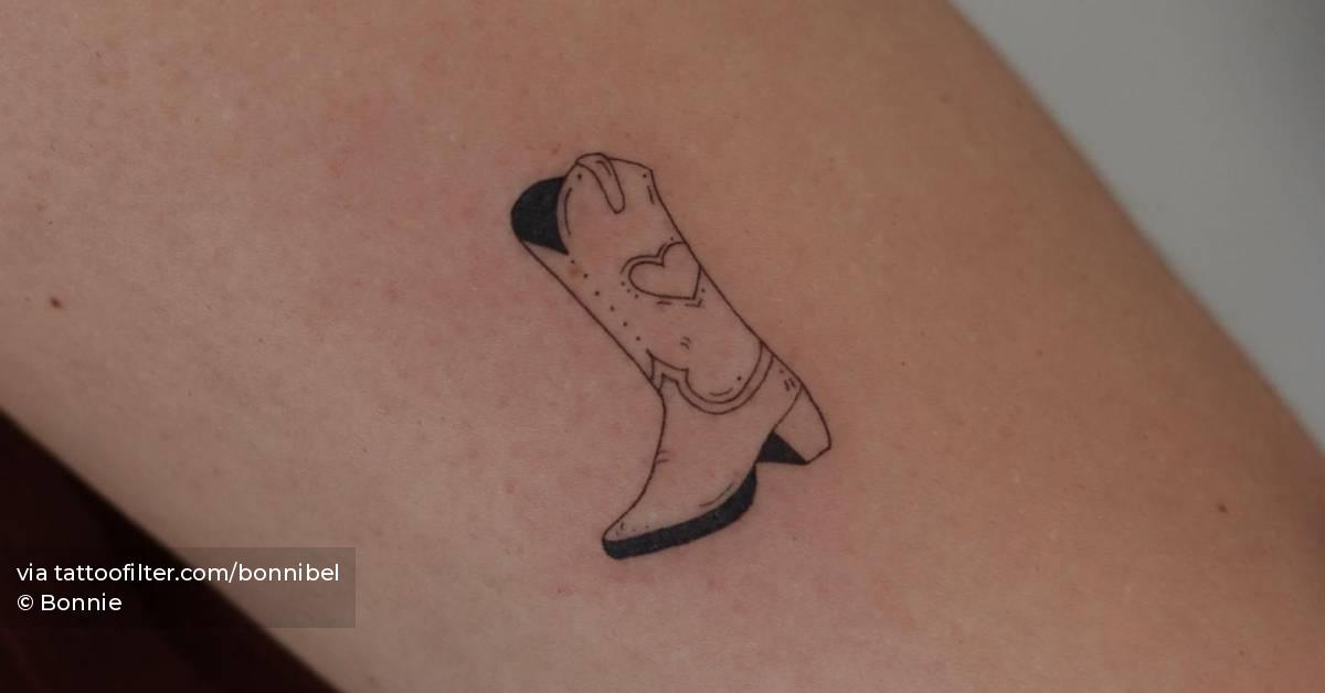 Fine line boot tattooed on the upper arm.