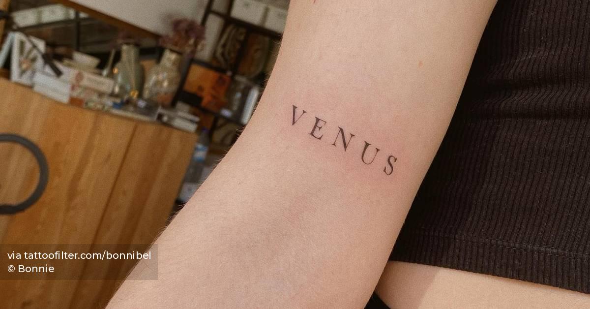 "Venus" lettering tattoo located on the bicep.