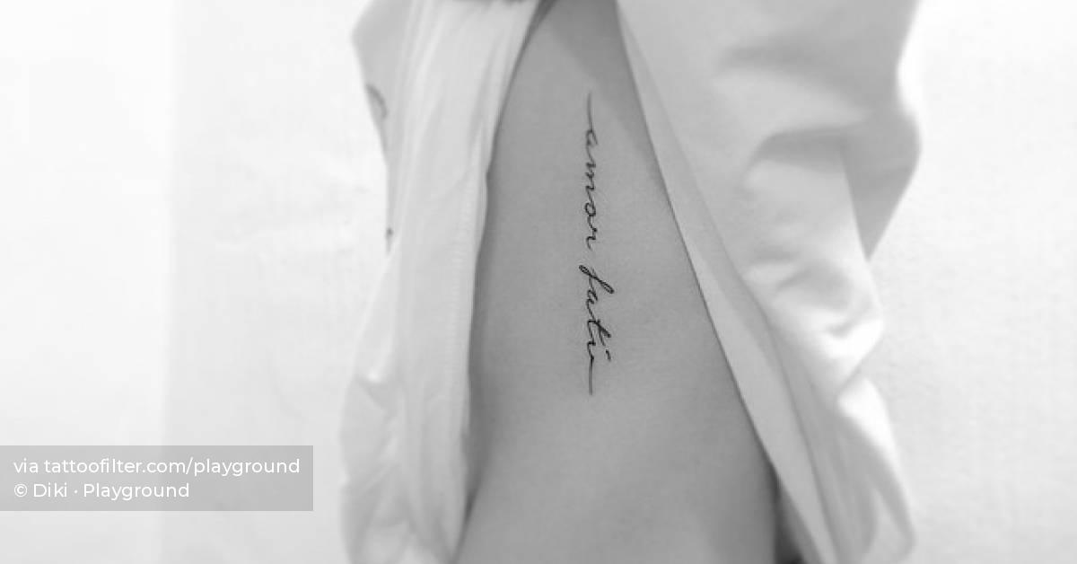 "Amor fati" lettering tattoo handwritten on the rib.