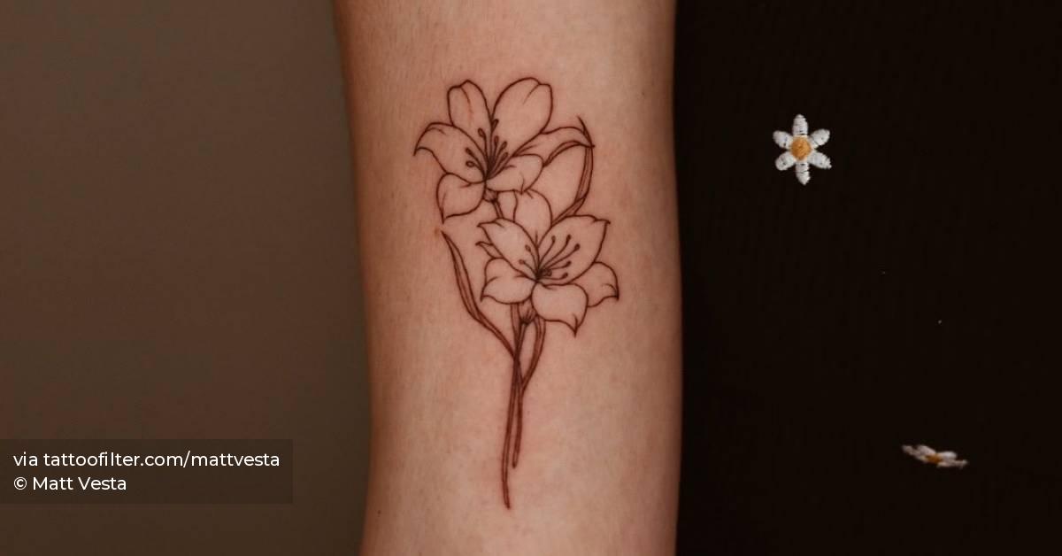 Fine line lily flowers tattooed on the inner arm.