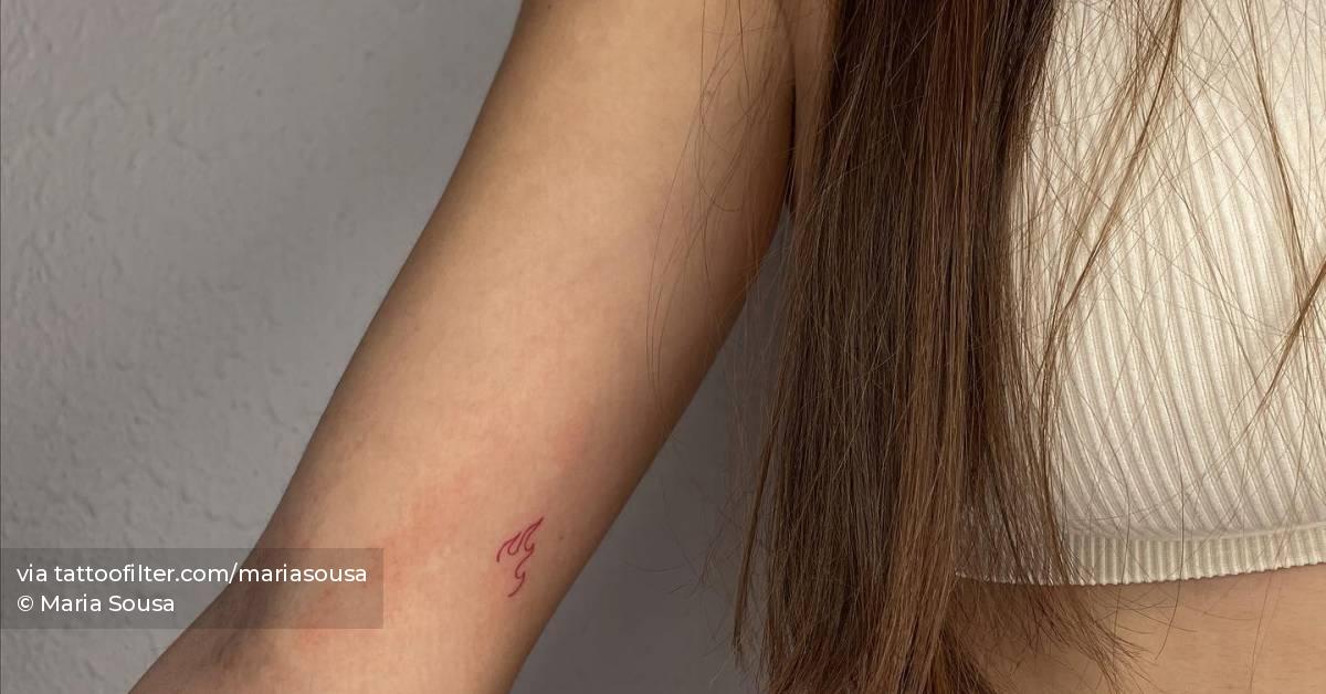 Red fire tattooed on the inner arm, minimalistic style.