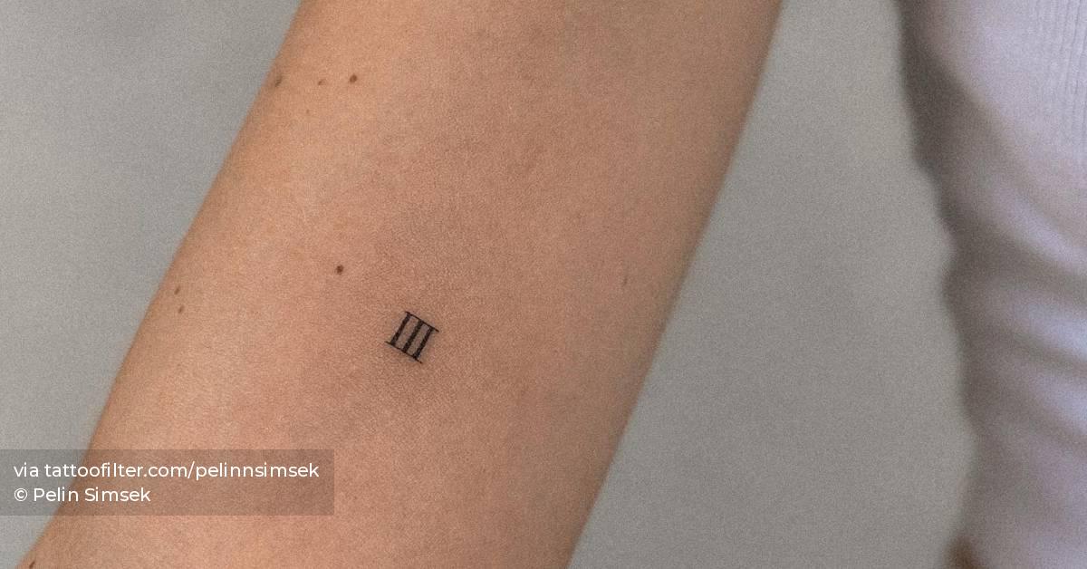 Roman numeral tattoo located on the inner arm.