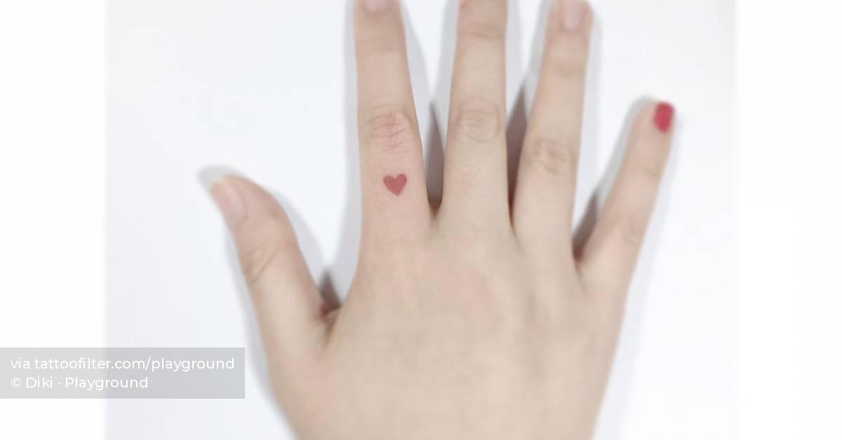 Minimalistic red heart tattooed on the finger.