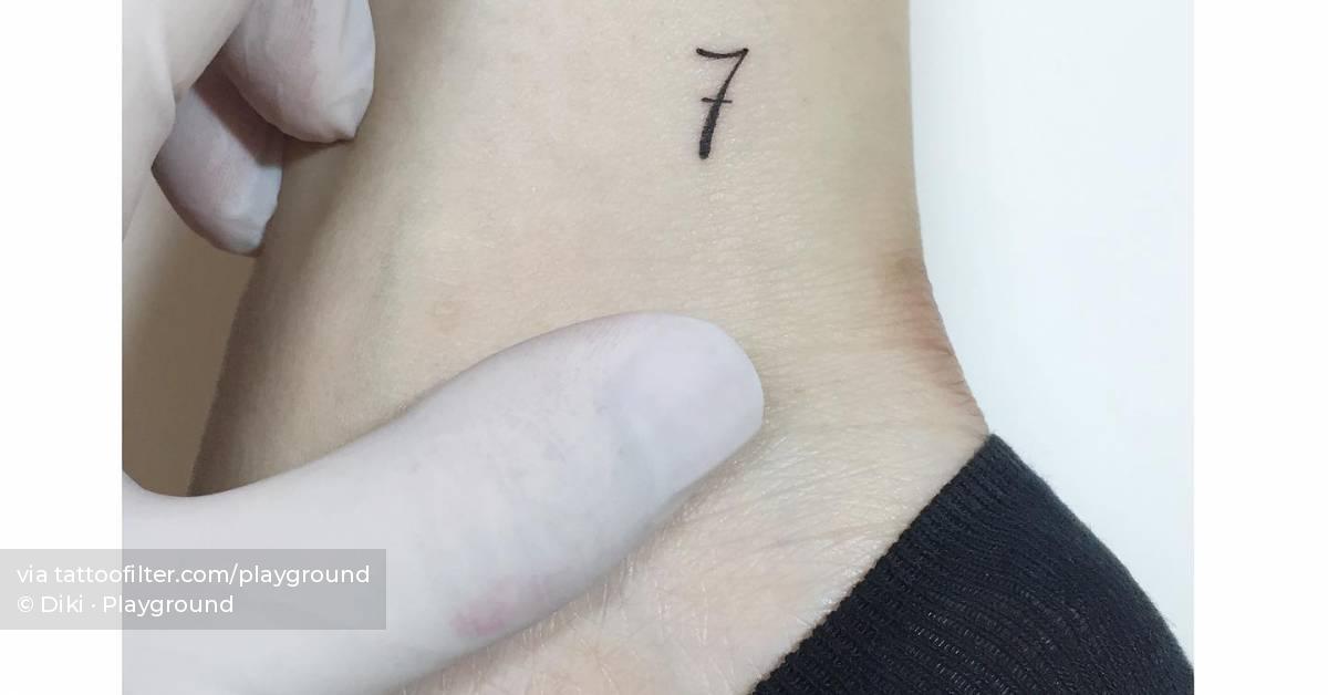 Minimalistic number "7" tattoo located on the ankle.