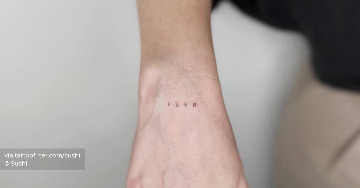 Word "baby" tattooed on the wrist.