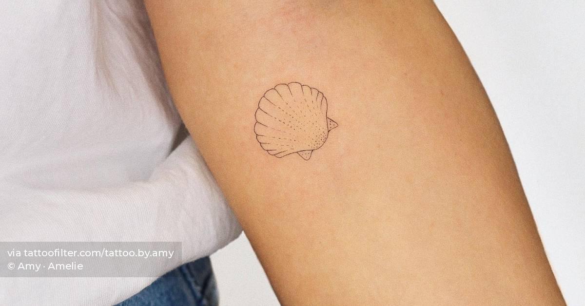 Fine line shell tattoo located on the inner forearm.
