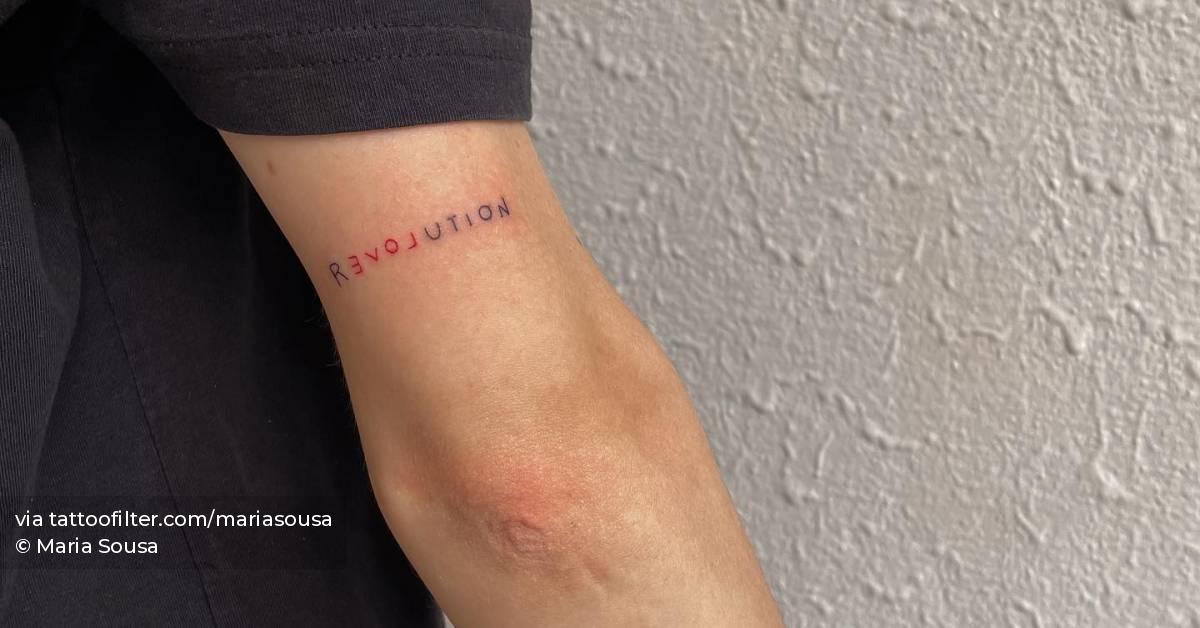Tattoo of the word "revolution" and a minimalistic