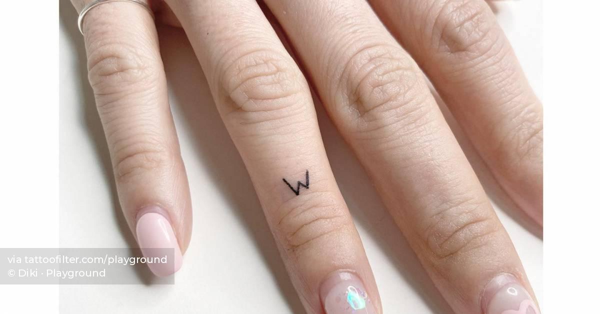 Tiny letter "W" tattoo located on the finger.