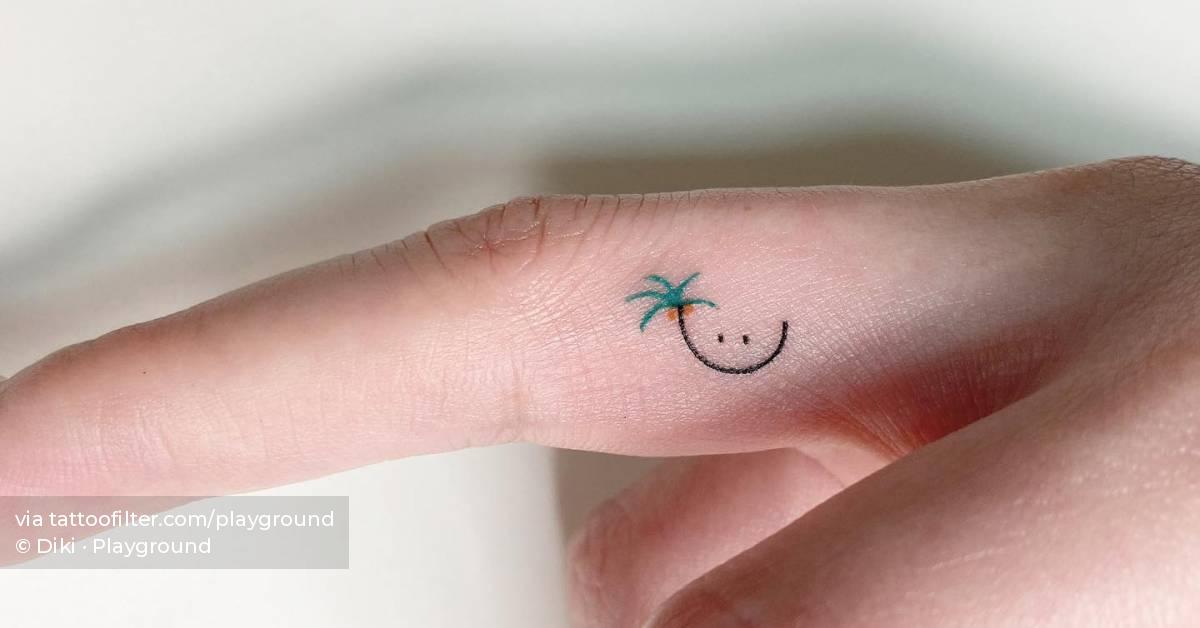 Minimalistic style smiley palm tree tattoo done on the