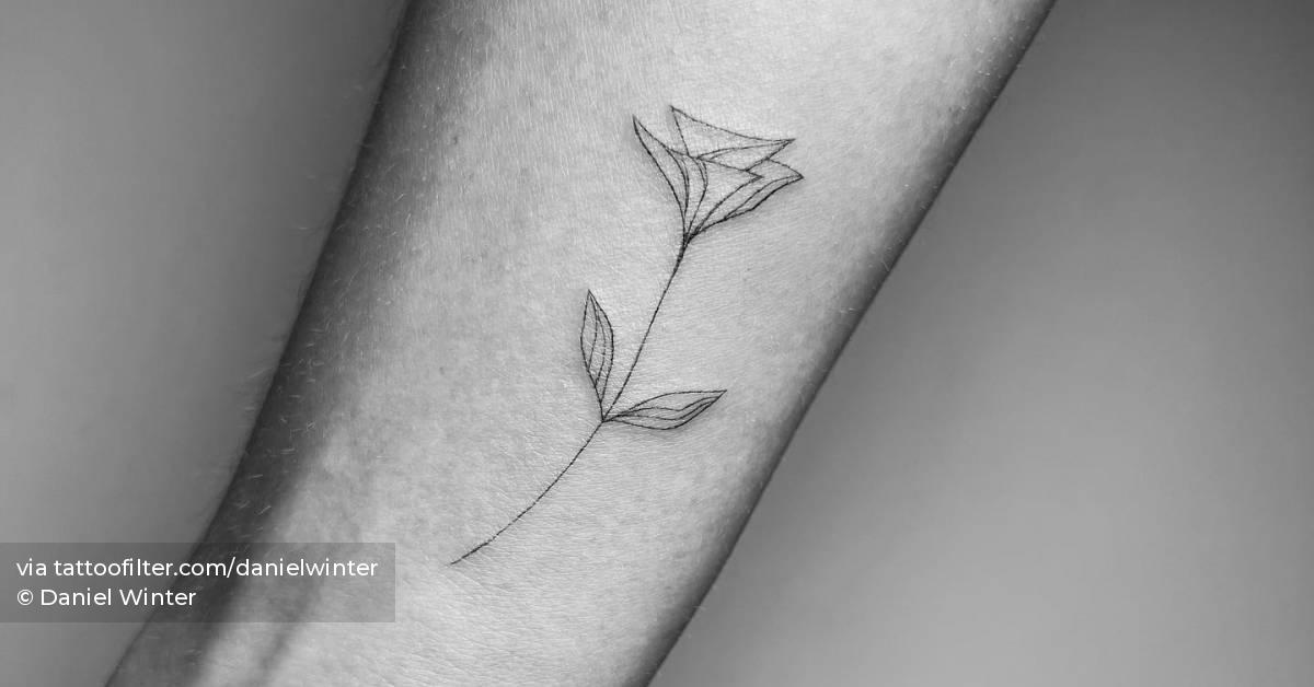 Fine line poppy flower tattoo located on the wrist.