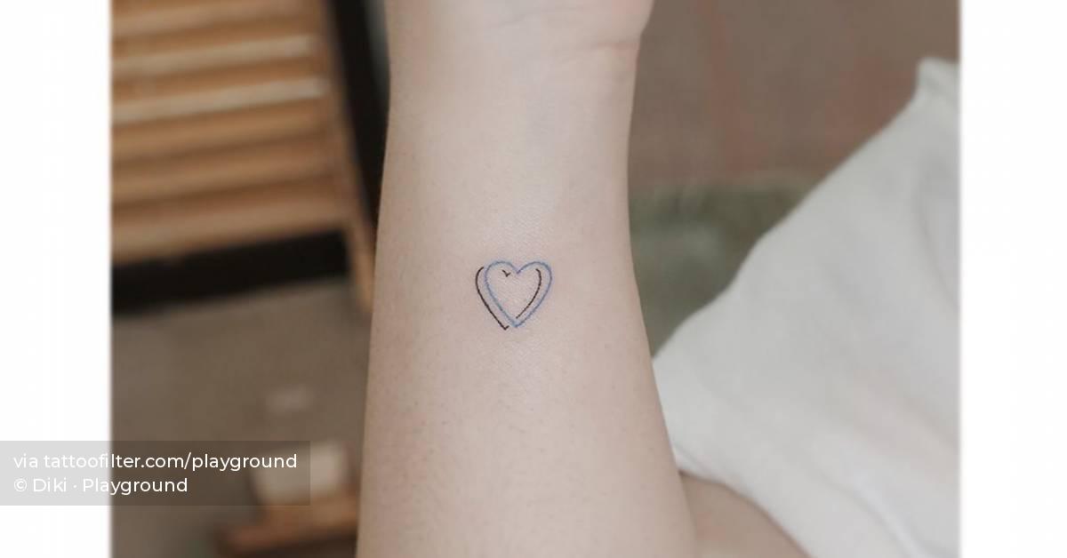 Fine line hearts tattooed on the wrist.