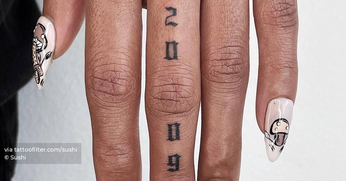 "2009" lettering tattoo done on the finger.