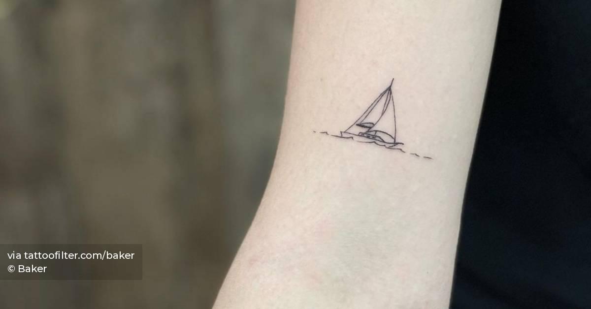 Tattoo of a sailboat located on the bicep, fine line