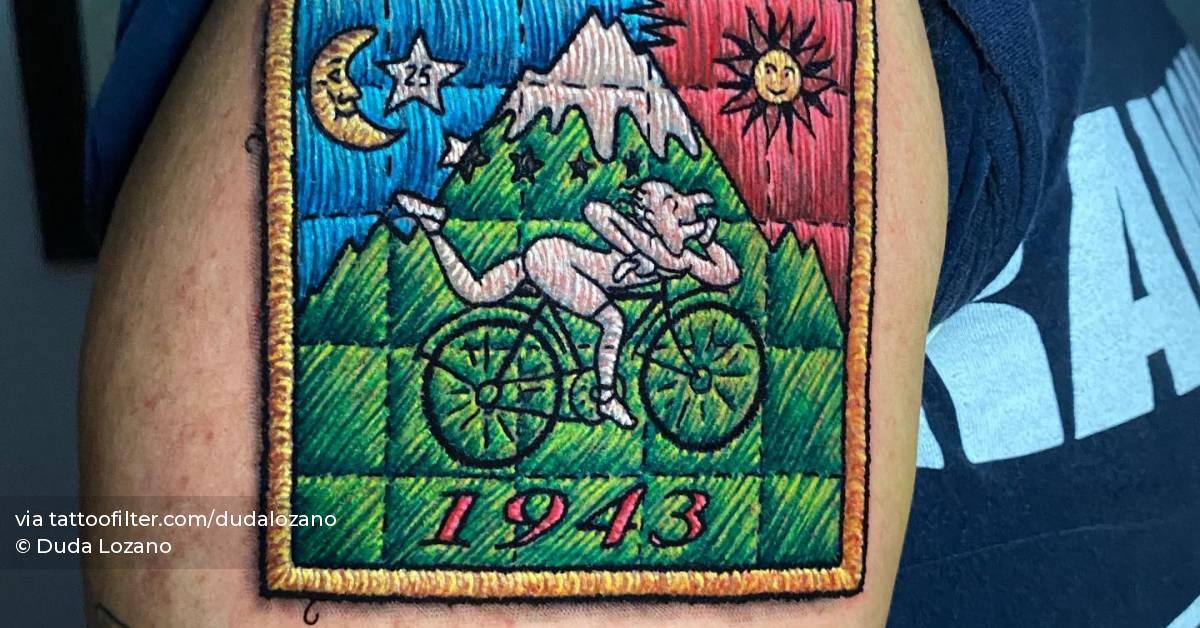 LSD trip patch tattoo located on the upper arm.