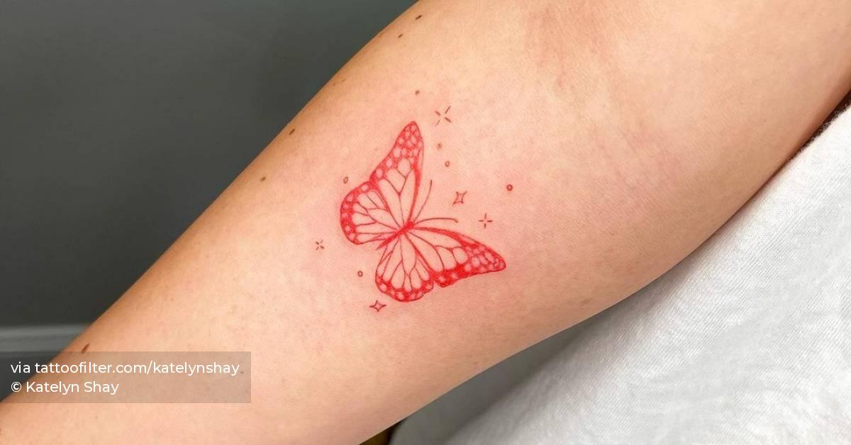Red butterfly tattoo located on the inner forearm.