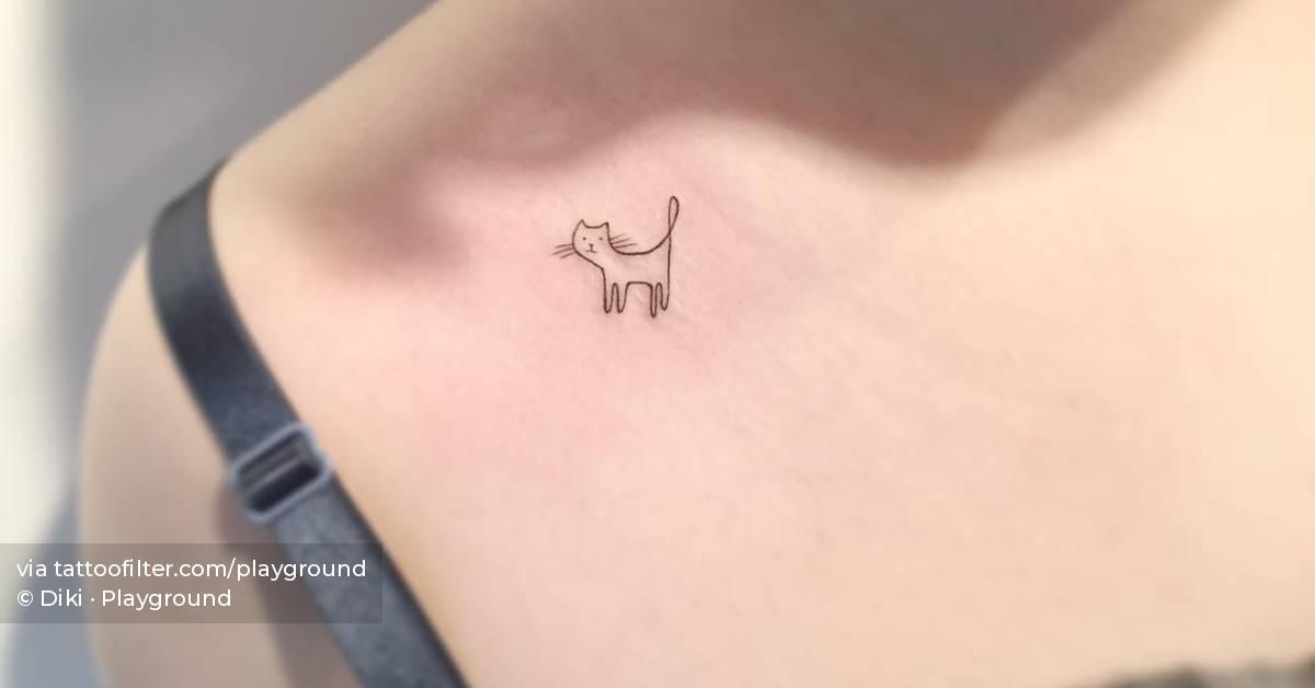 Fine line cat tattoo located on the collarbone.