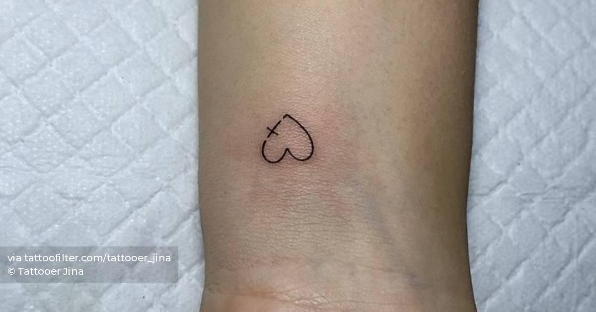 Minimalist cross and heart tattoo on the wrist