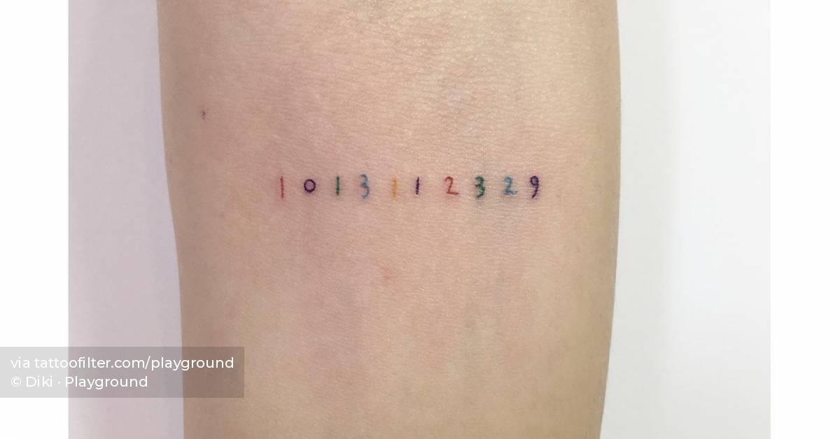 Colorful numbers tattoo located on the inner forearm.