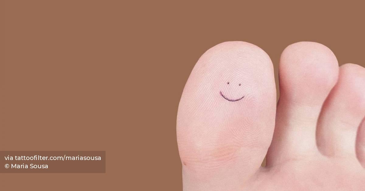 Minimalist smile tattoo on the toe.