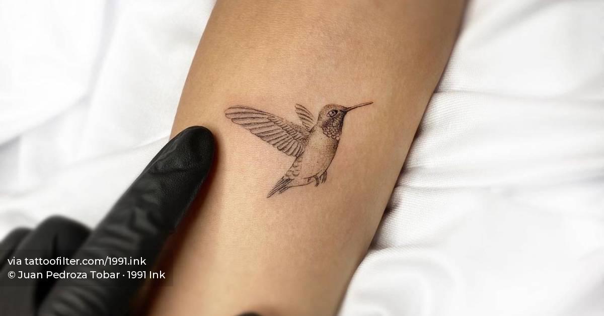 Fine line hummingbird tattoo on the inner forearm